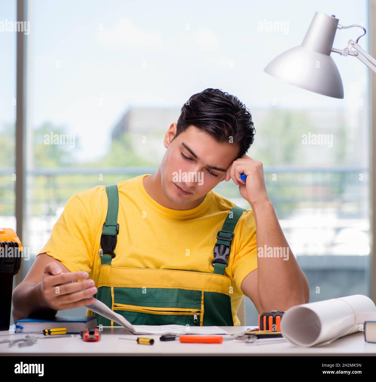 The construction worker sitting at the desk Stock Photo - Alamy