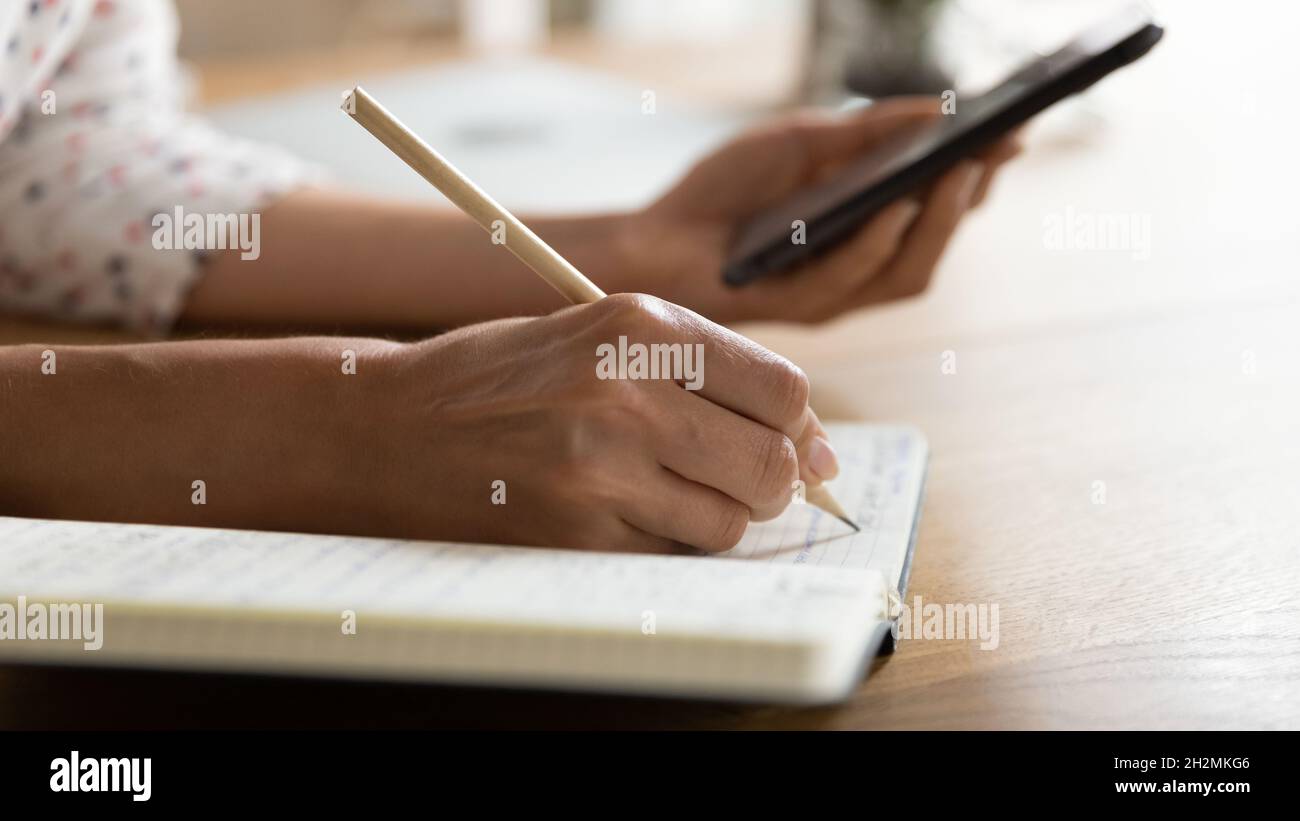Female student writing in notebook, watching learning webinar Stock ...