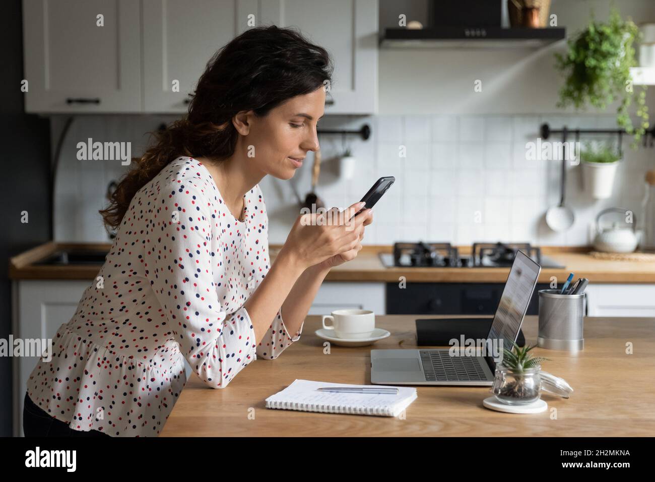 Female Hispanic remote employee working at laptop from home Stock Photo ...