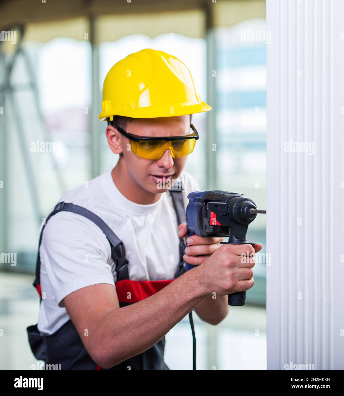 The man drilling the wall with drill perforator Stock Photo - Alamy