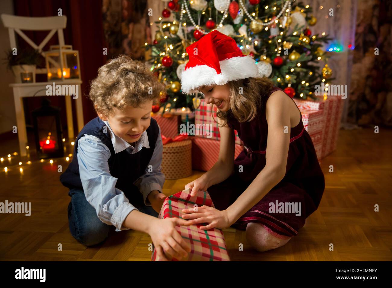 Excited cute kids happily smiling, opening Christmas gifts. Beautifully ...