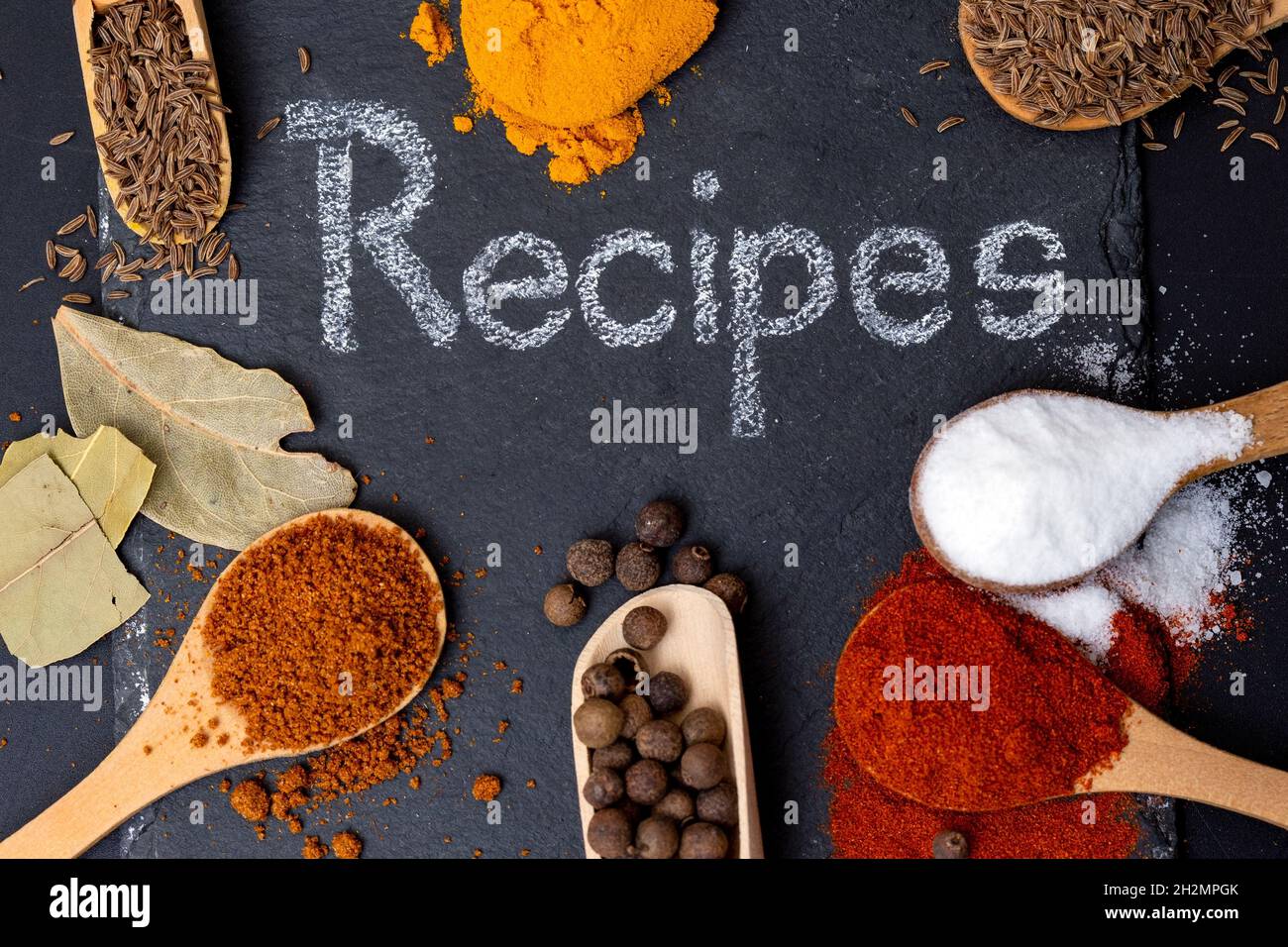 recipes written with white chalk on a black stone tile, surrounded by ...