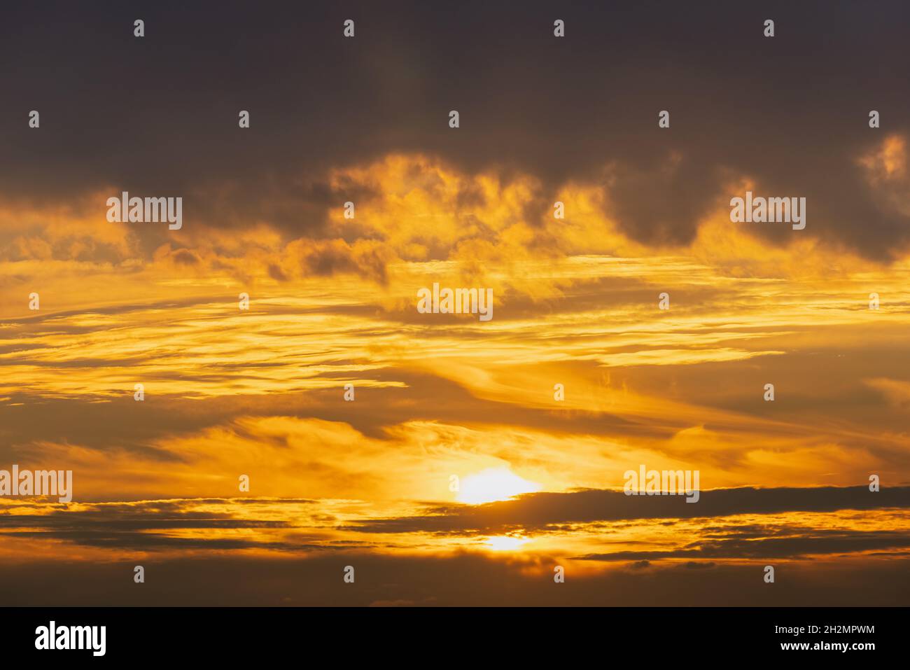 The setting sun lighting up the cloud cover just above the horizon ...
