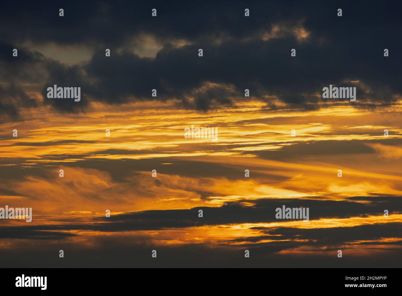 The setting sun lighting up the cloud cover just above the horizon ...