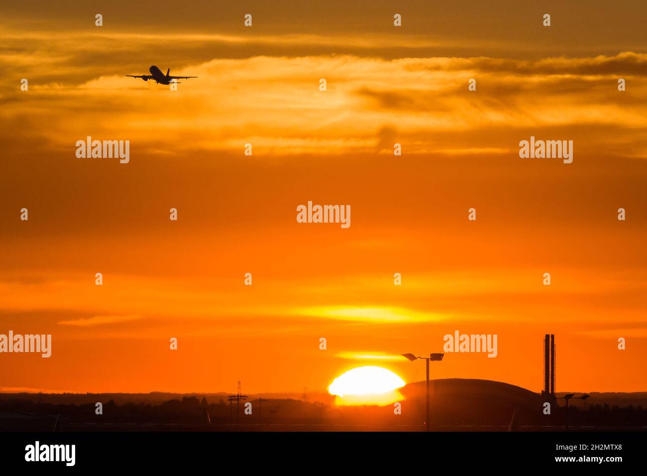 Airplane departing from London Heathrow airport in late afternoon with ...