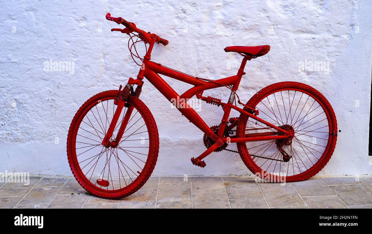 red bike with punctured wheel on white wall Stock Photo - Alamy