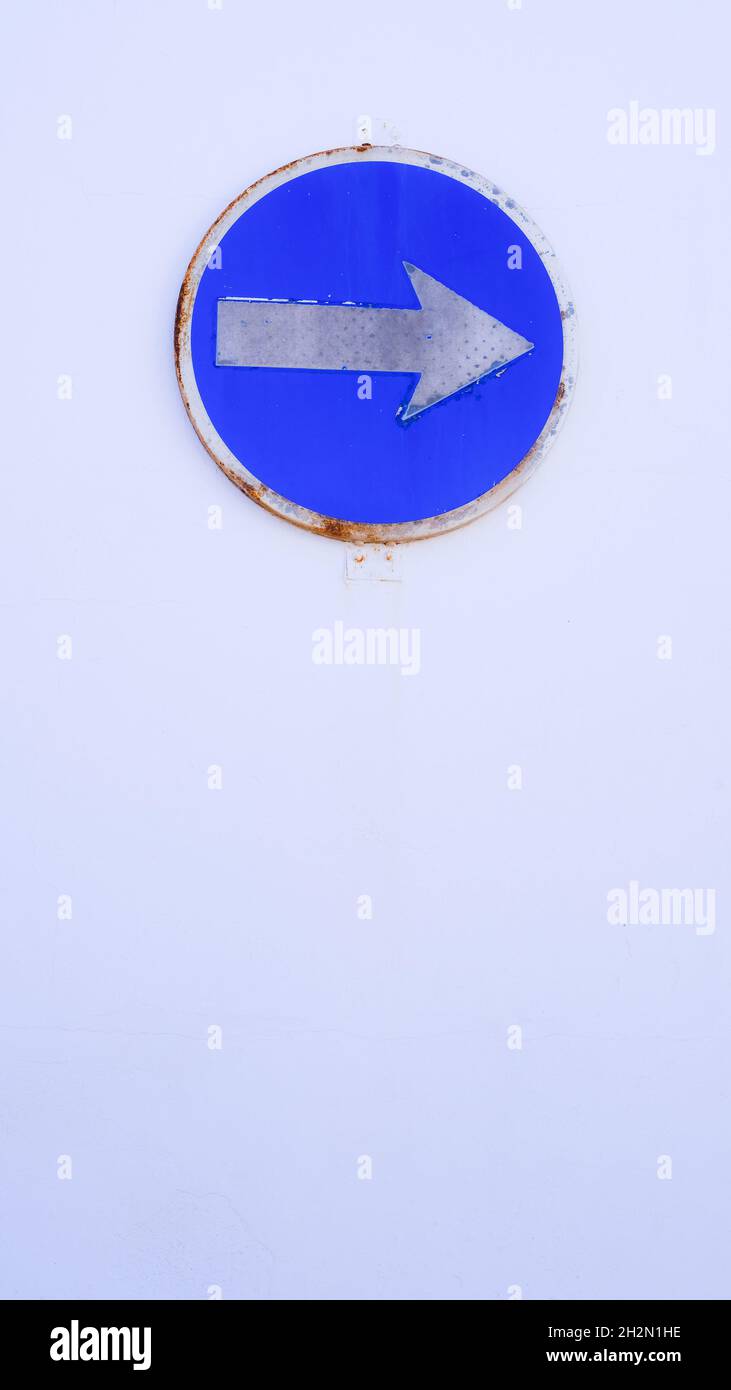 direction obligation sign on white wall. white arrow, blue sign Stock ...