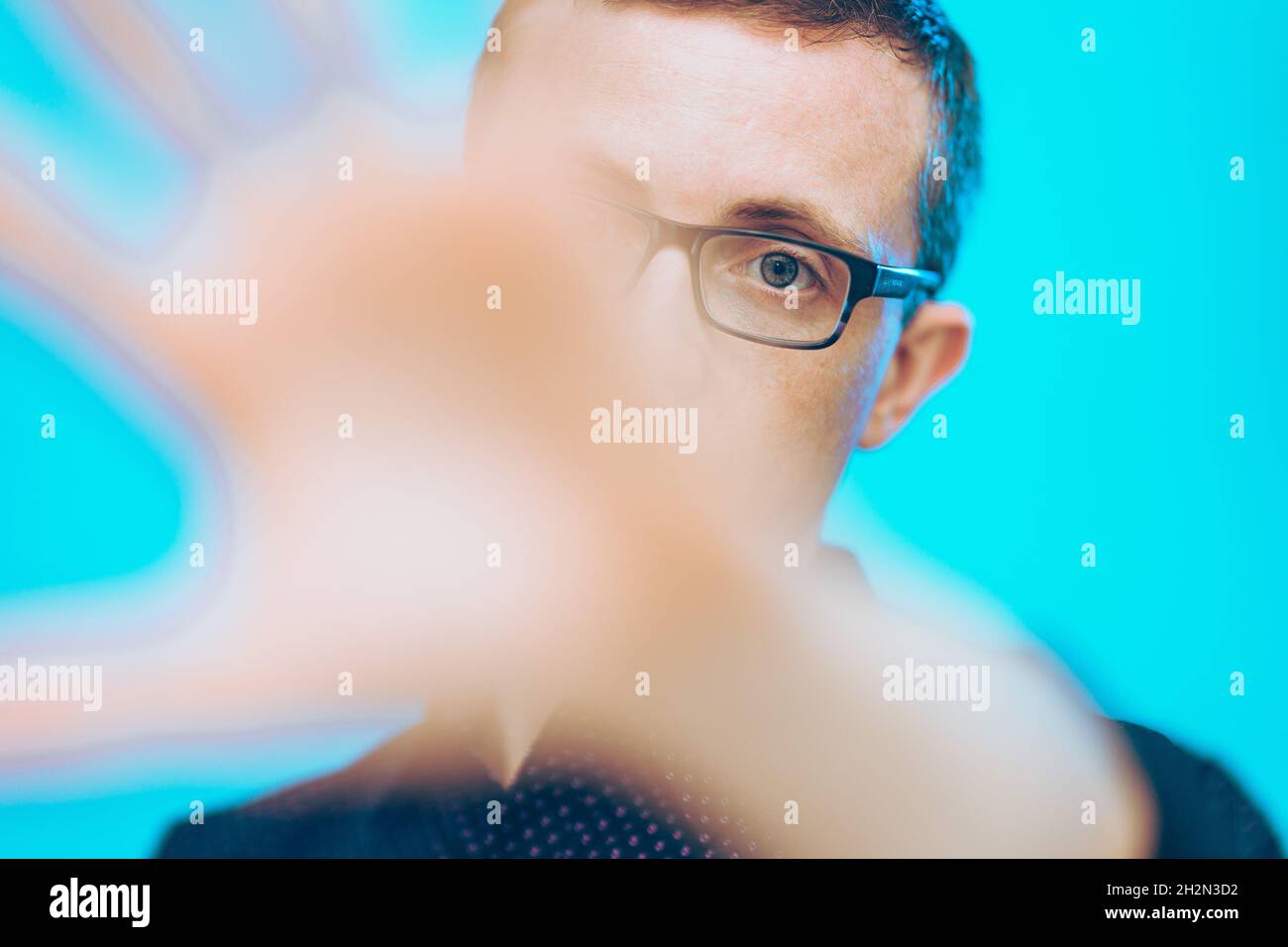 American man in glasses covering the camera with his hand Stock Photo ...