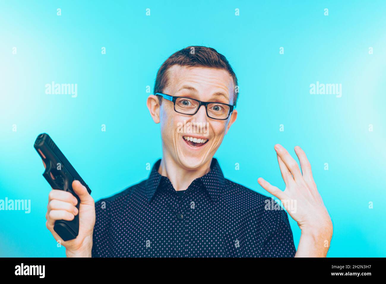 American man in a shirt holding a gun with a crazy look Stock Photo - Alamy