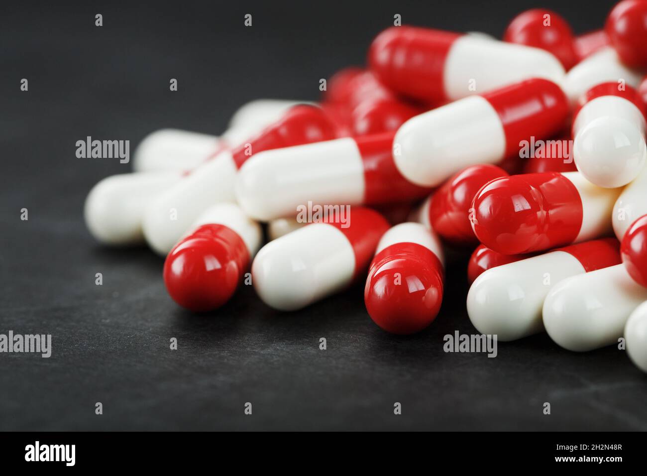 Medical red and white capsules isolated on a black background. Capsules ...