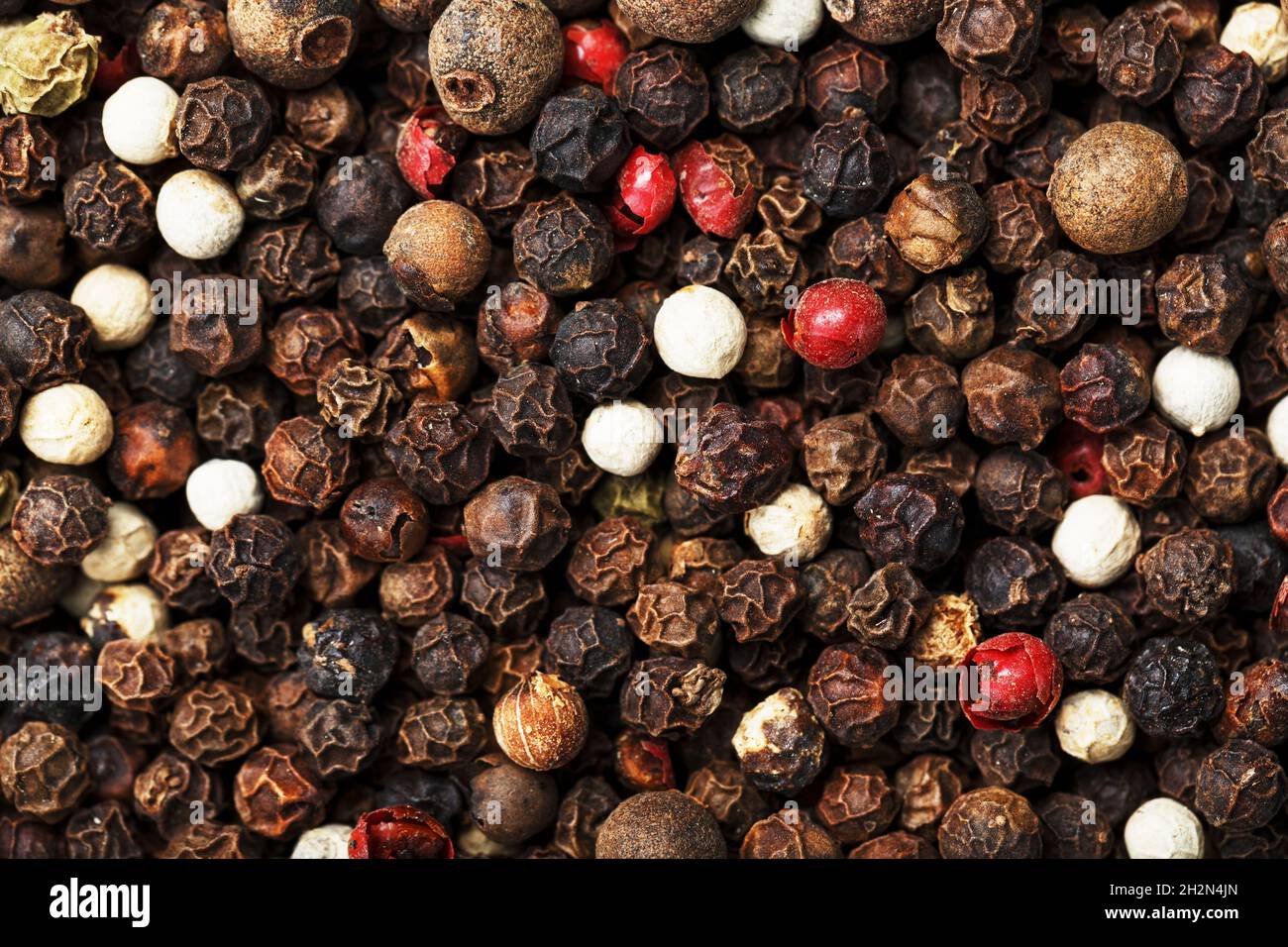 A mixture of peppercorns as a textural background in full screen ...