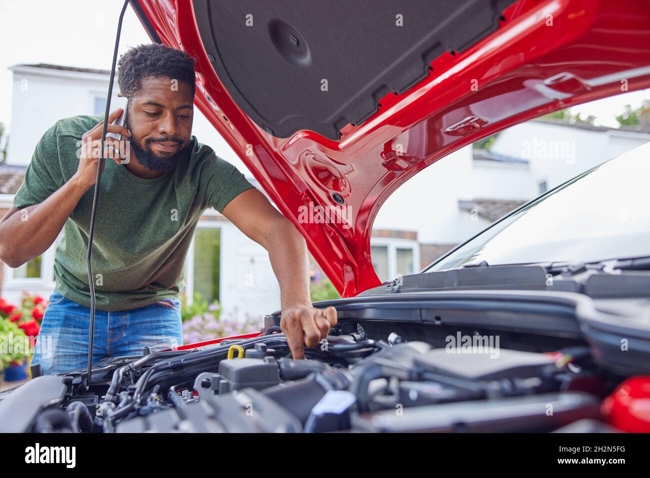 Man Looking At Engine After Car Breakdown Calling Auto Recovery On ...