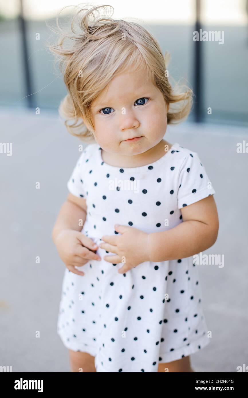 cute baby girl looking up at the camera. Vertical shot Stock Photo - Alamy