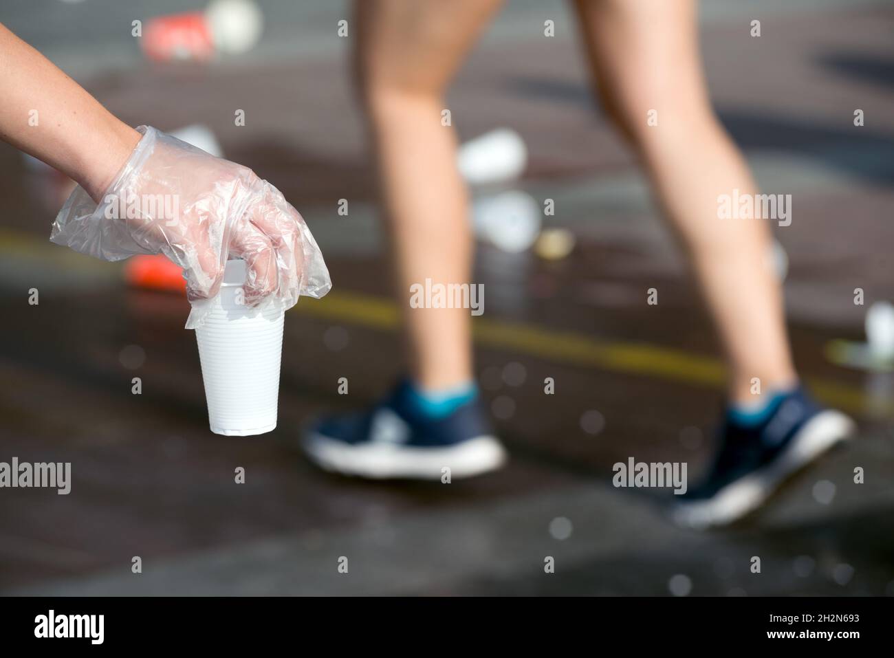 Hand in glove holding cup hi-res stock photography and images - Alamy