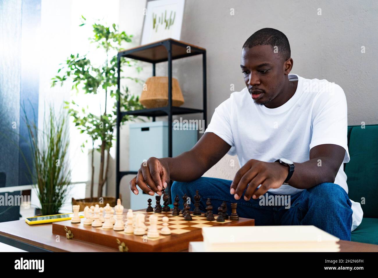 Smiling man playing chess at home Stock Photo - Alamy