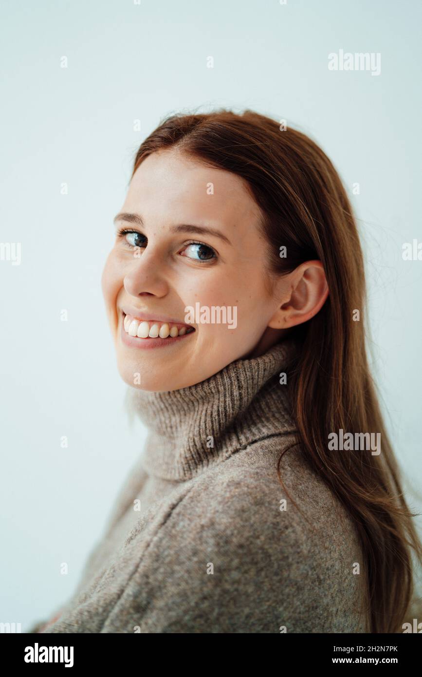 Smiling woman with brown hair by white background Stock Photo - Alamy