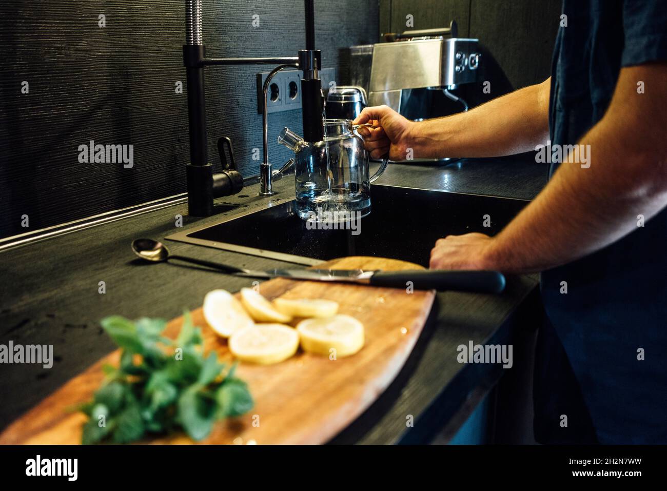 Man filling water in jar at sink Stock Photo - Alamy