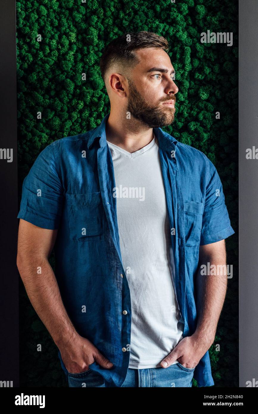 Man with hands in pockets standing in front of wall Stock Photo - Alamy