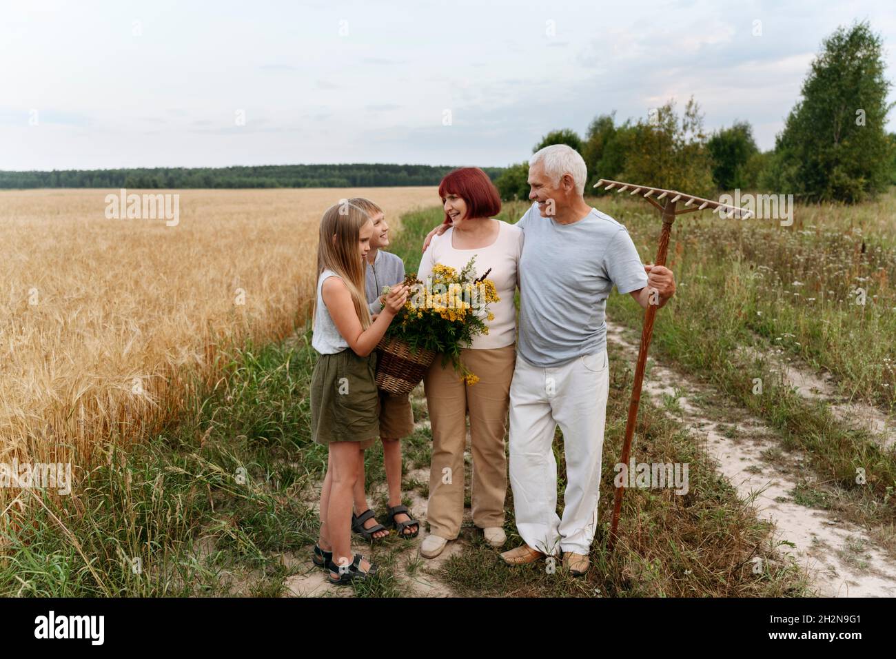 Happy family with flowers and rake at field Stock Photo - Alamy