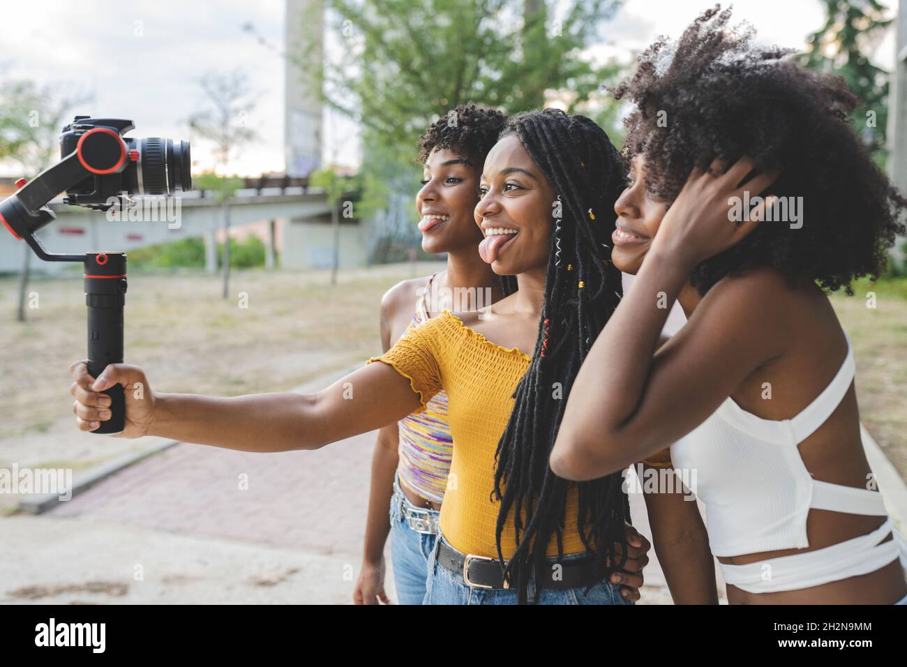 Smiling female friends vlogging through camera Stock Photo - Alamy
