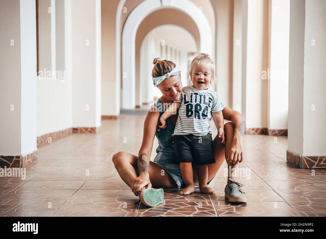 Smiling mother with playful son in corridor Stock Photo - Alamy