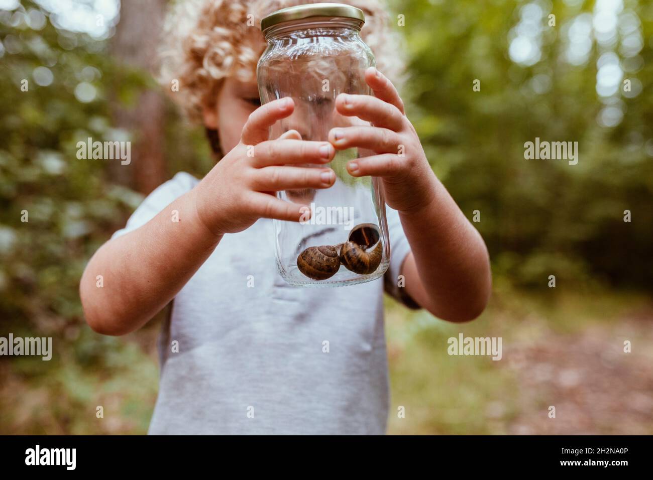 Boy holding glass jar with snails Stock Photo - Alamy