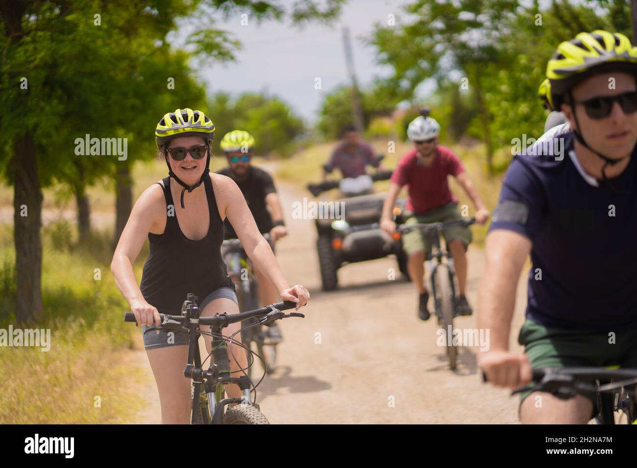 Group of friends are riding their bikes together while enjoying the sun ...