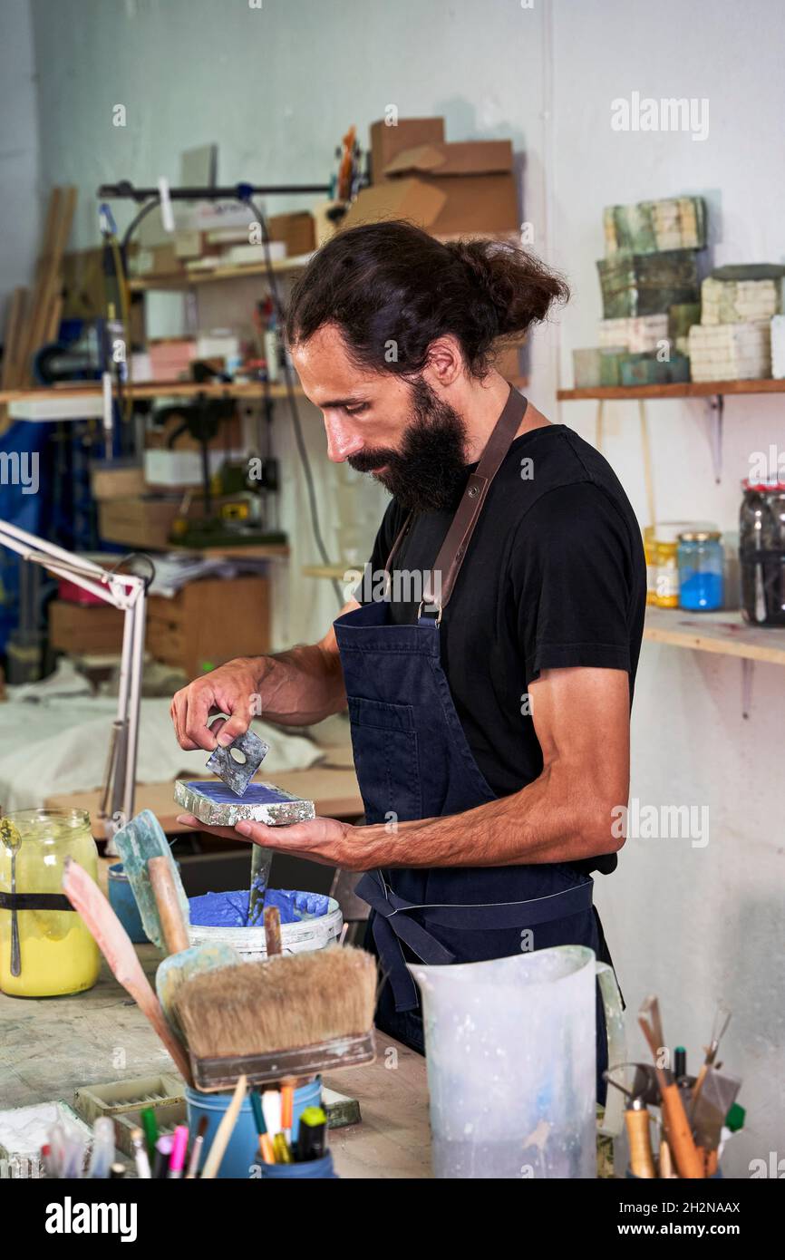 Male craftsperson coloring concrete while standing at workbench Stock ...