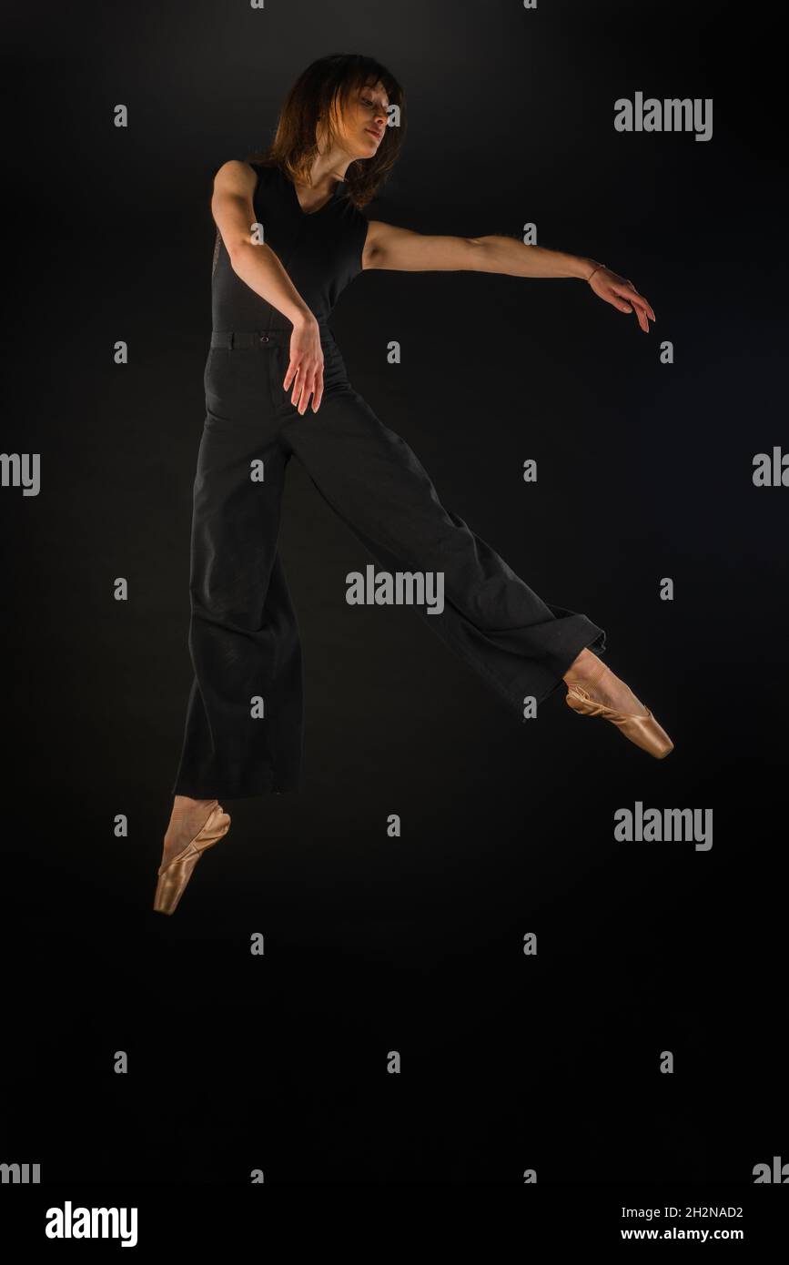 Ballerina is doing a perfect ballet jump while perfect holding her ...