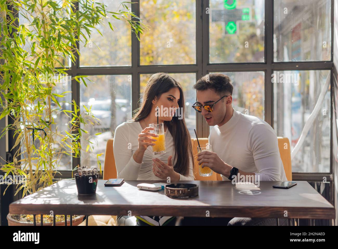 Friends socializing, having fun, and laughing drinking coffee in ...