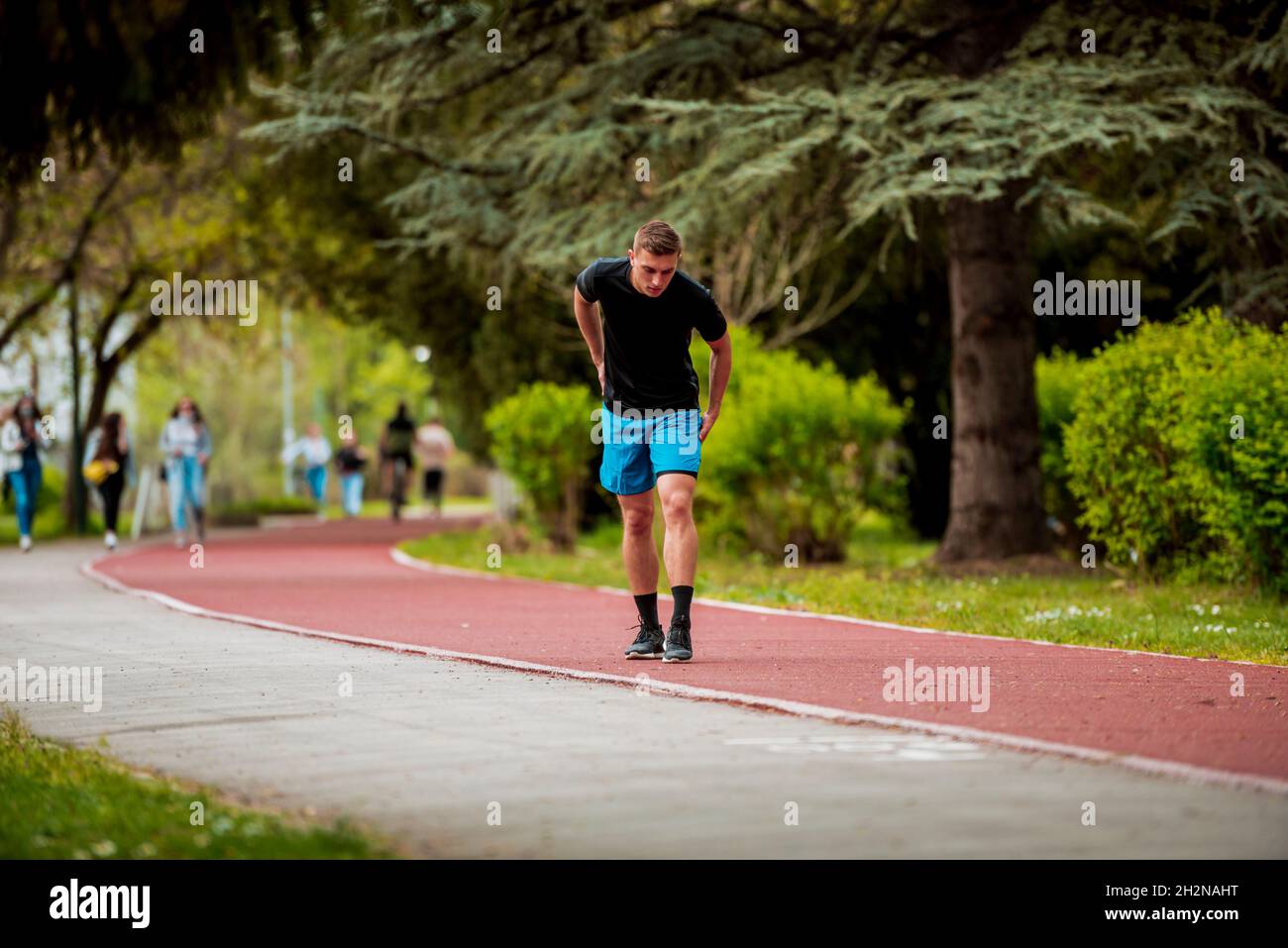 Fitness running man jogging on athletics stadium track open air during ...