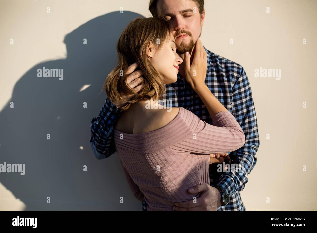 Girlfriend hugging boyfriend in front of wall Stock Photo - Alamy