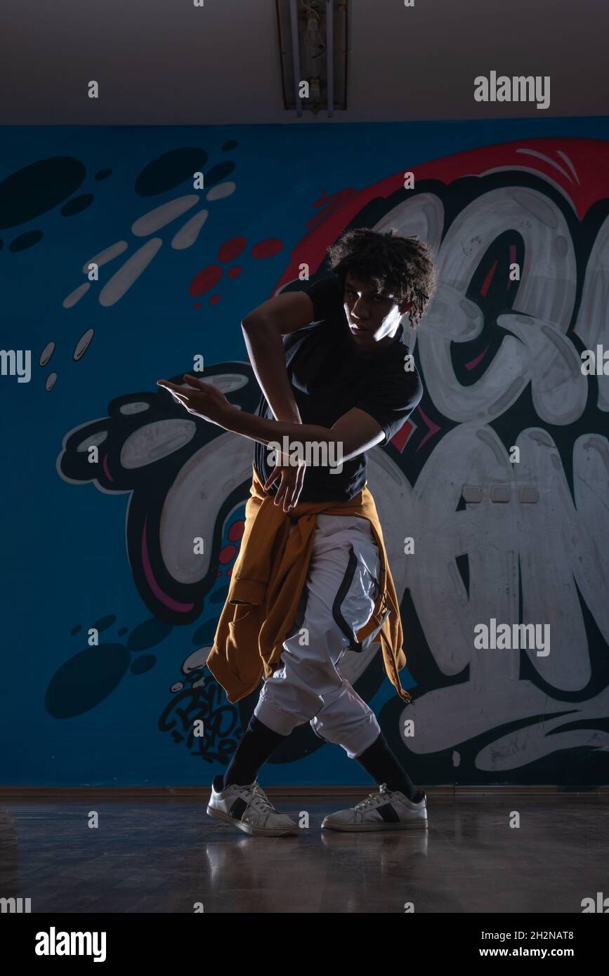 African American hip hop dancer (breakdancer) performing over graffiti ...