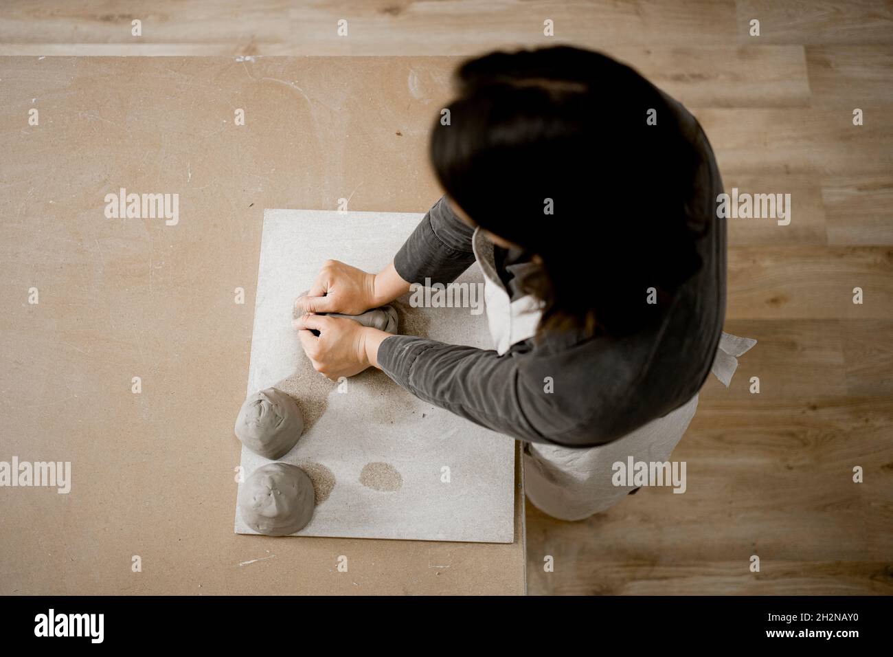 Young female potter molding clay on workbench Stock Photo - Alamy