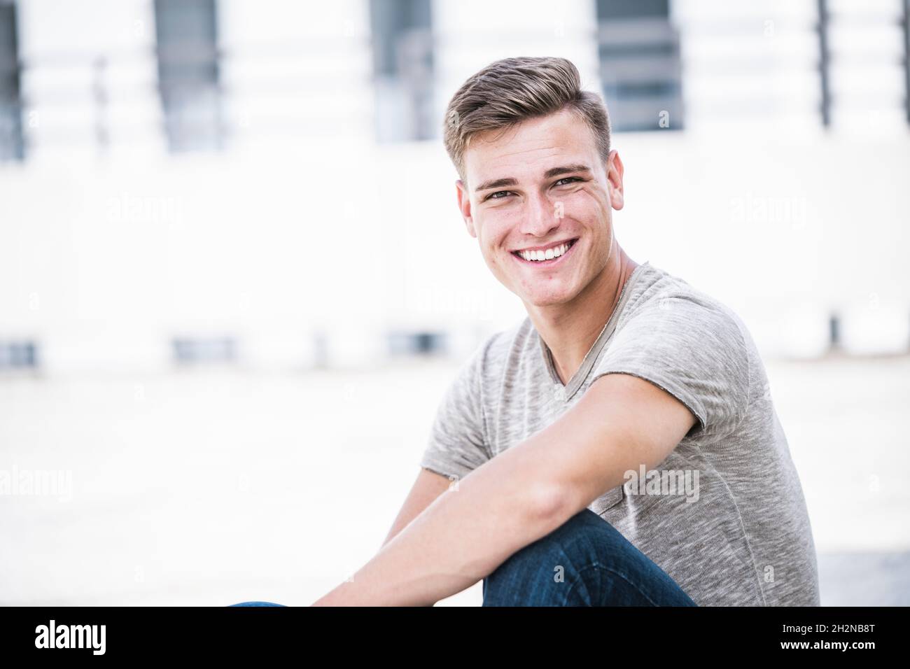 Happy man sitting on rooftop Stock Photo - Alamy