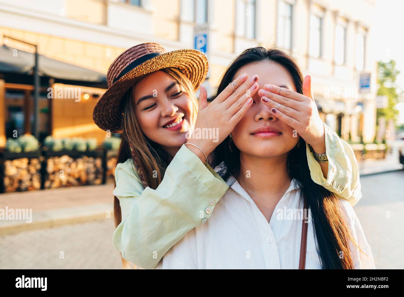 Woman covering friends eyes hi-res stock photography and images - Alamy