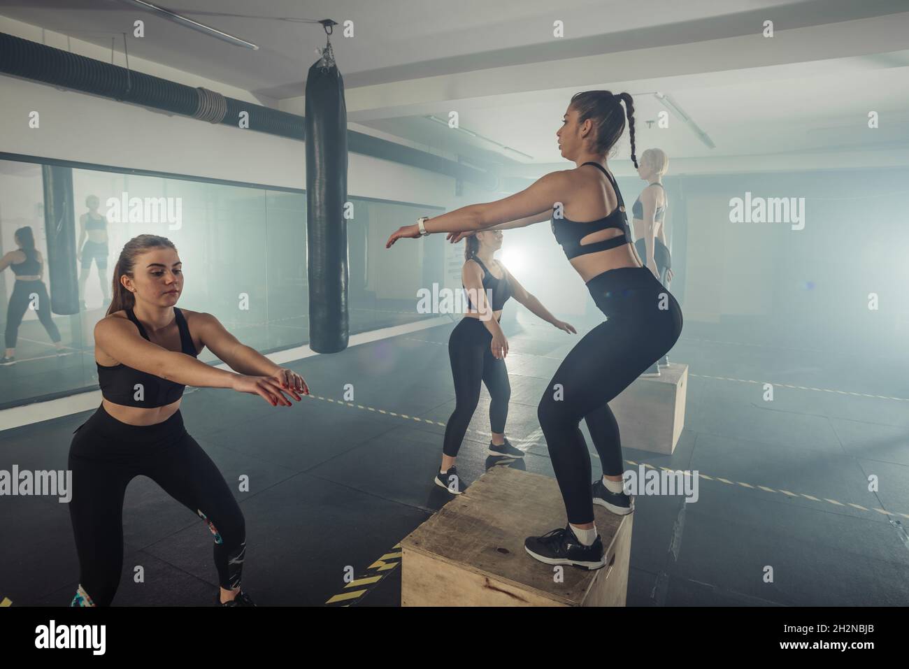 Fit young women doing box squat exercises at the crossfit gym Stock ...