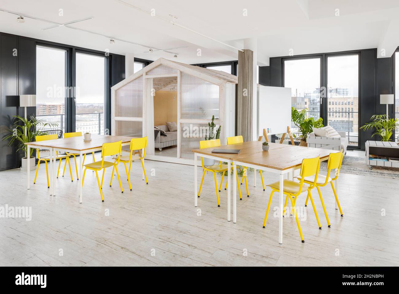 Chairs arranged around desk in coworking office Stock Photo - Alamy