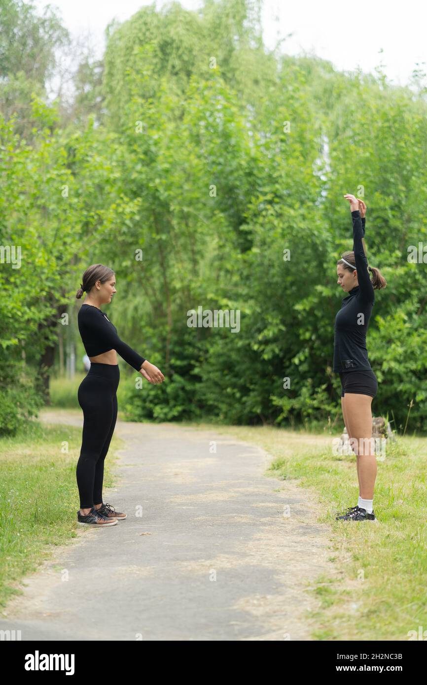 Two attractive and beautiful girls are stretching and warming up their ...