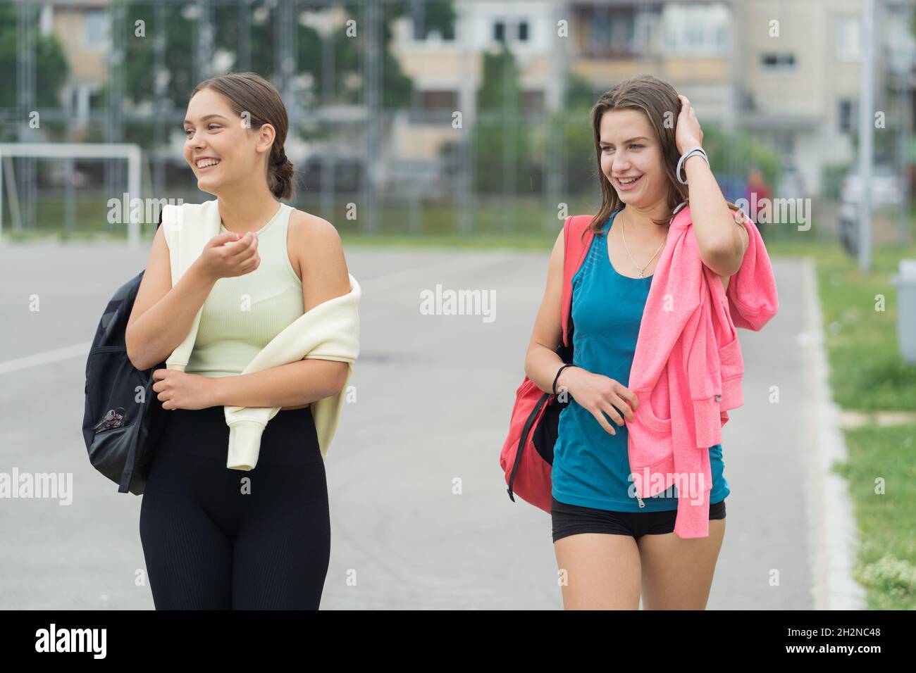 Two beautiful girl friends are talking about the weather while smiling ...