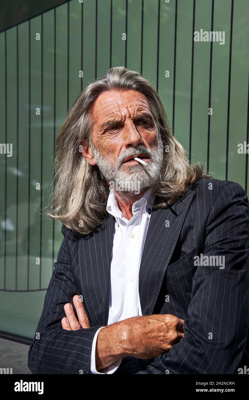 Man standing cigarette crossed arms hi-res stock photography and images ...