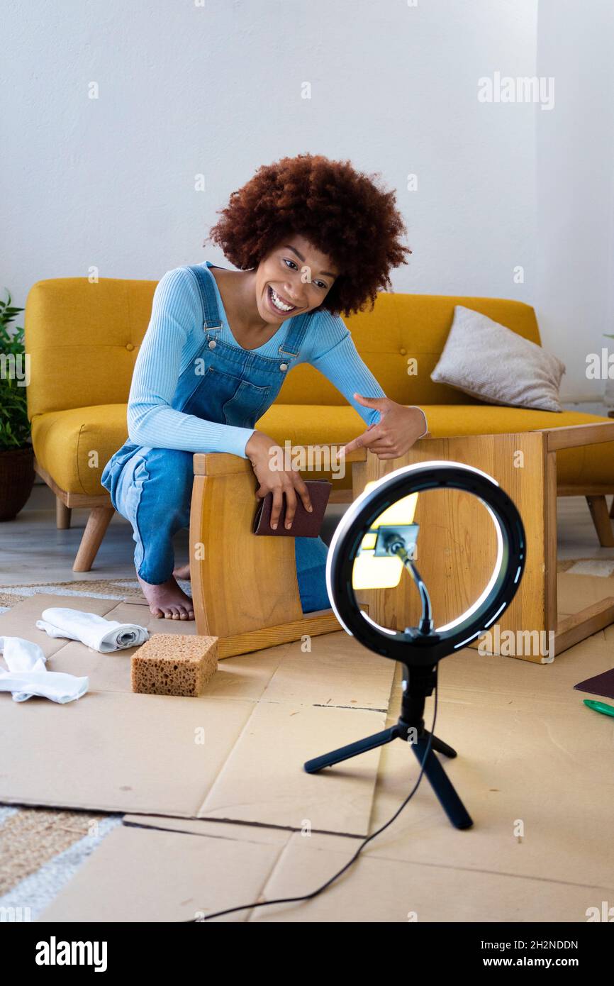 Female influencer polishing wicker basket while vlogging through smart ...
