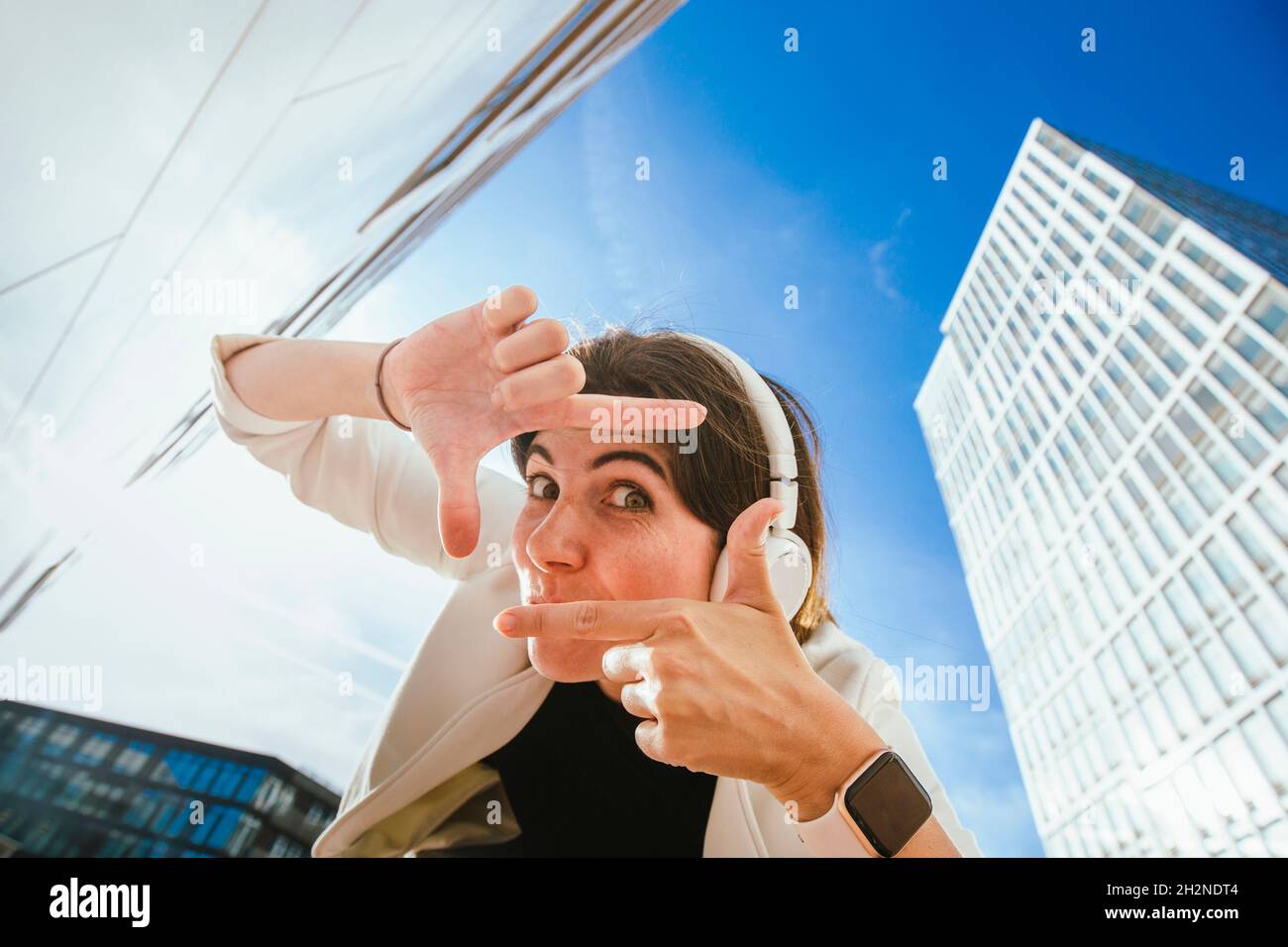 Businesswoman making finger frame by building during sunny day Stock ...