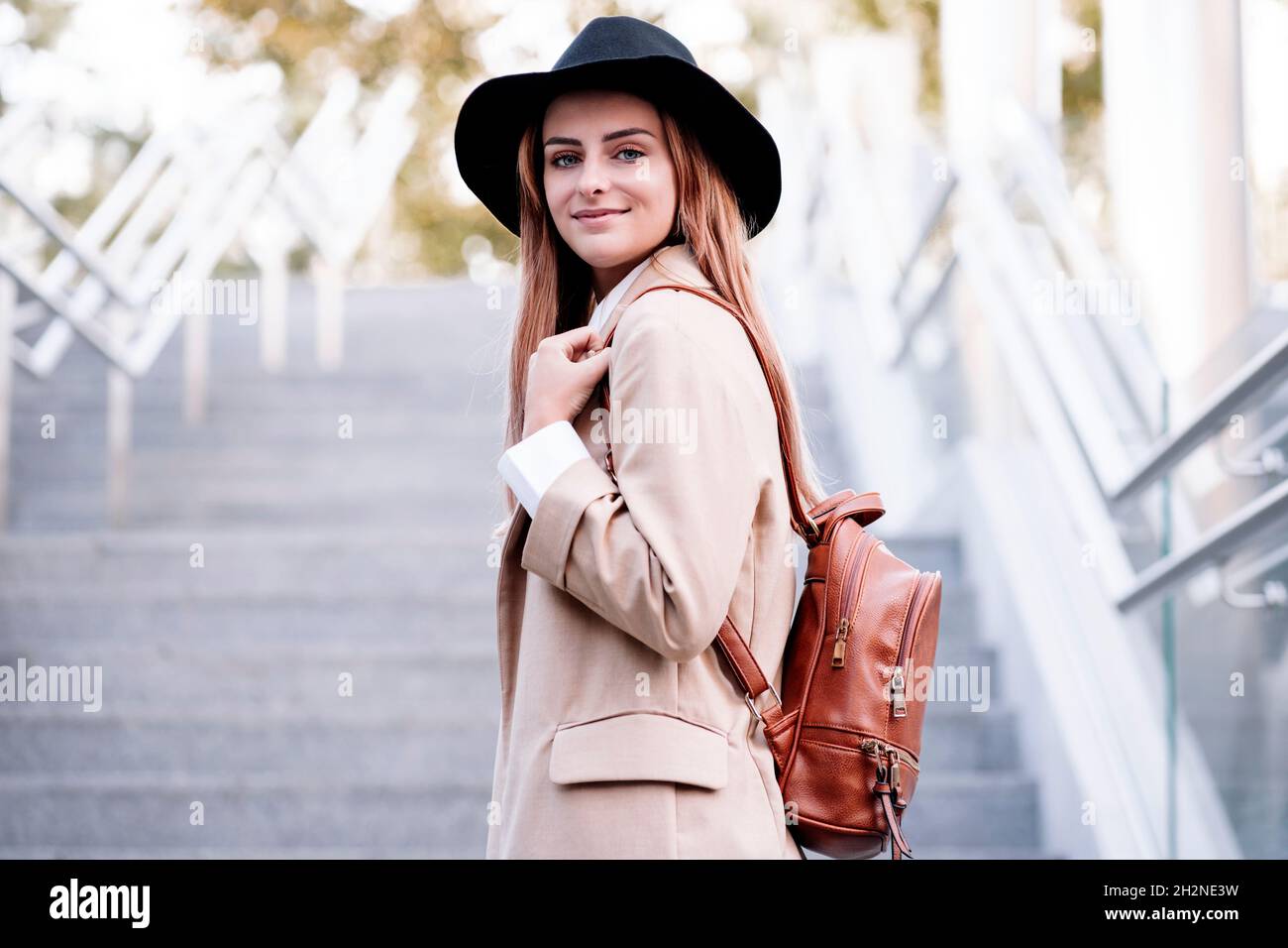 Smiling young woman backpack wearing hi-res stock photography and ...