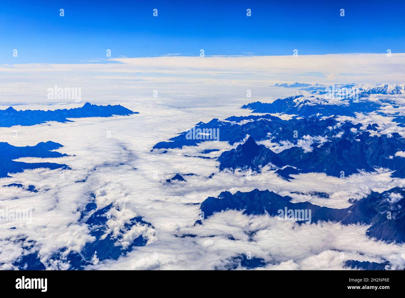 Aerial view above the clouds and mountain peaks on a sunny day Stock ...