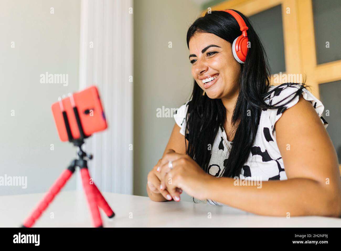 Happy woman vlogging through mobile phone at home Stock Photo - Alamy