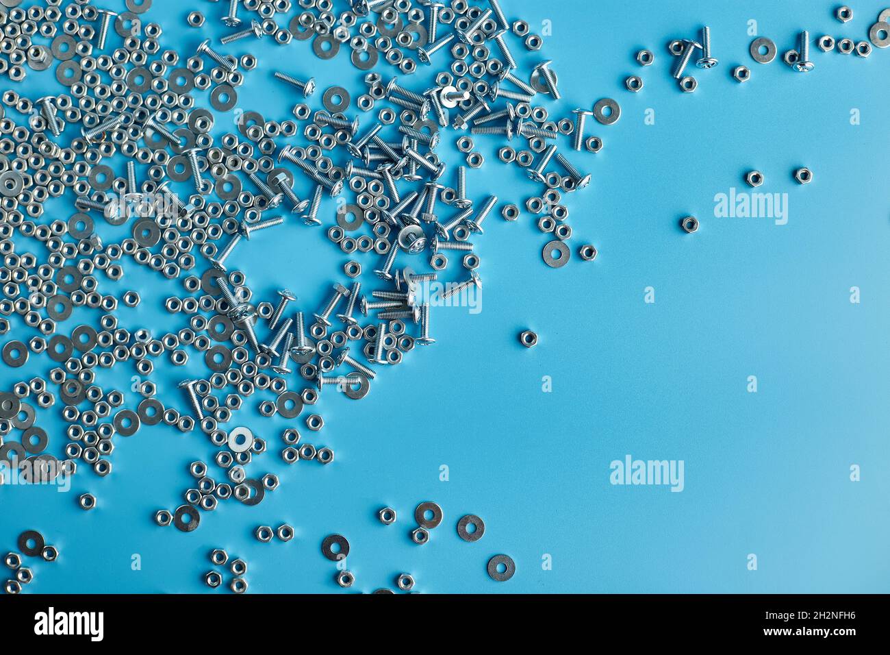 Top view, flat lay Metal screw, nuts and bolts on blue background, Working tools, Fixing ...