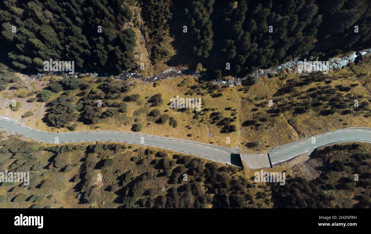 Aerial view of winding road stretching along mountain river Stock Photo ...