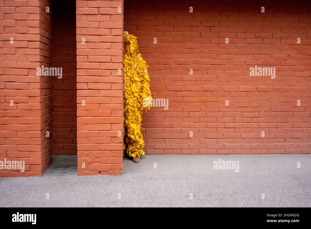 Woman in yellow costume standing behind architectural column Stock ...