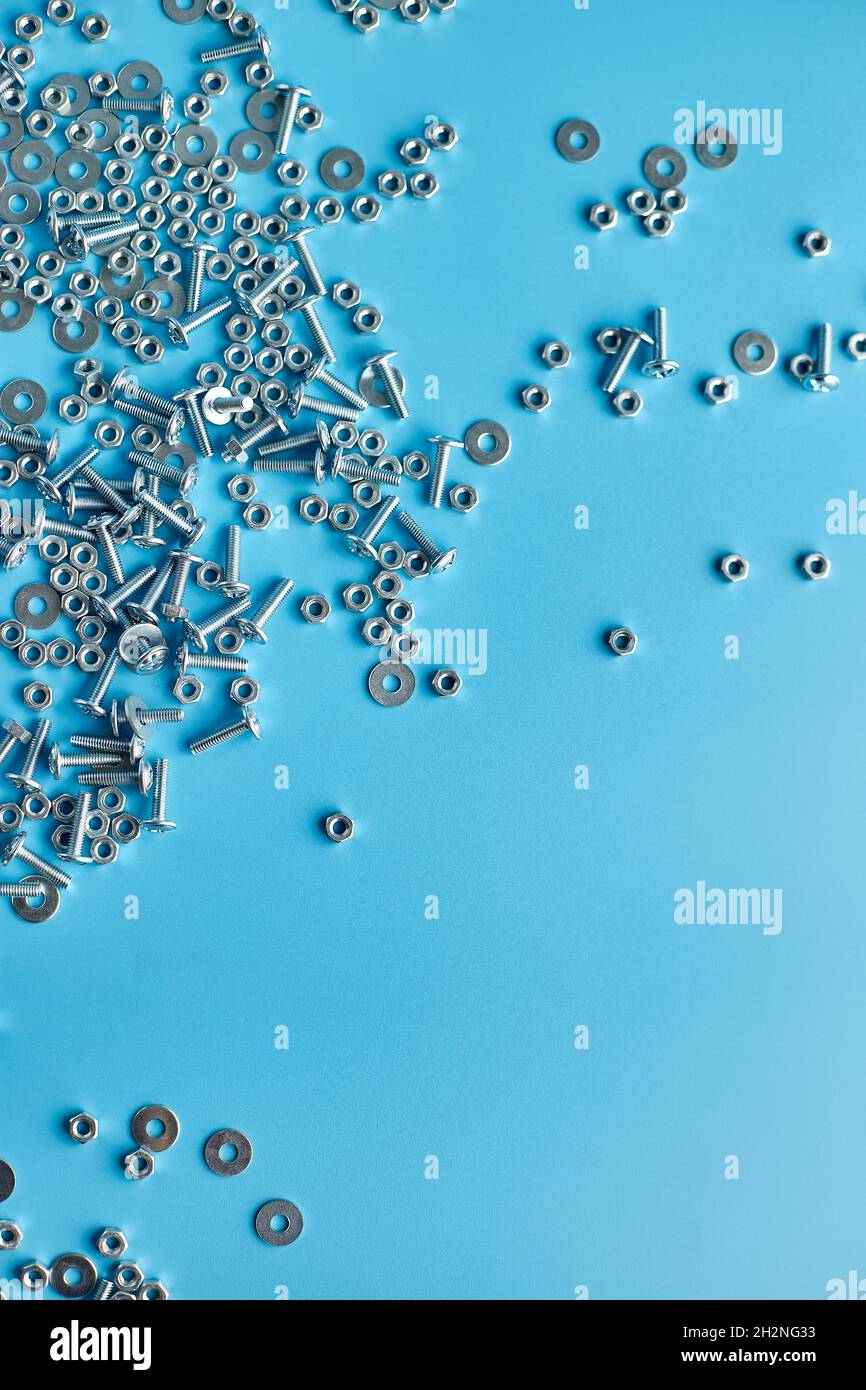 Top view, flat lay Metal screw, nuts and bolts on blue background, Working tools, Fixing ...